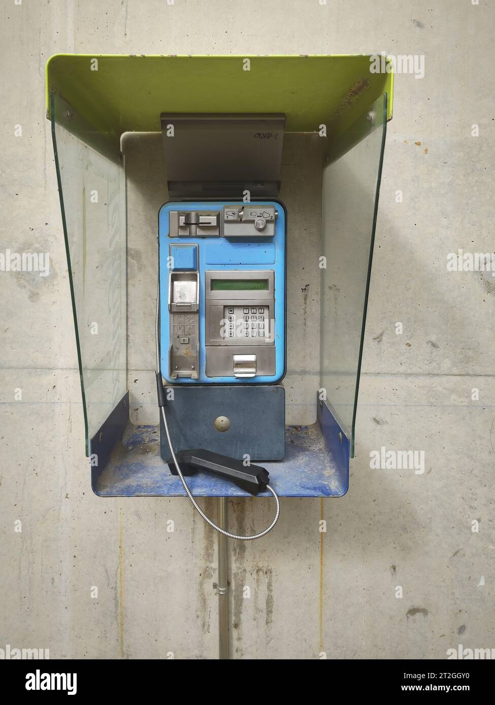 Detail of an old public telephone booth on the wall of the street in ...
