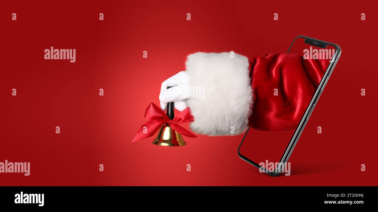 Mobile phone and hand of Santa Claus with Christmas bell on red ...