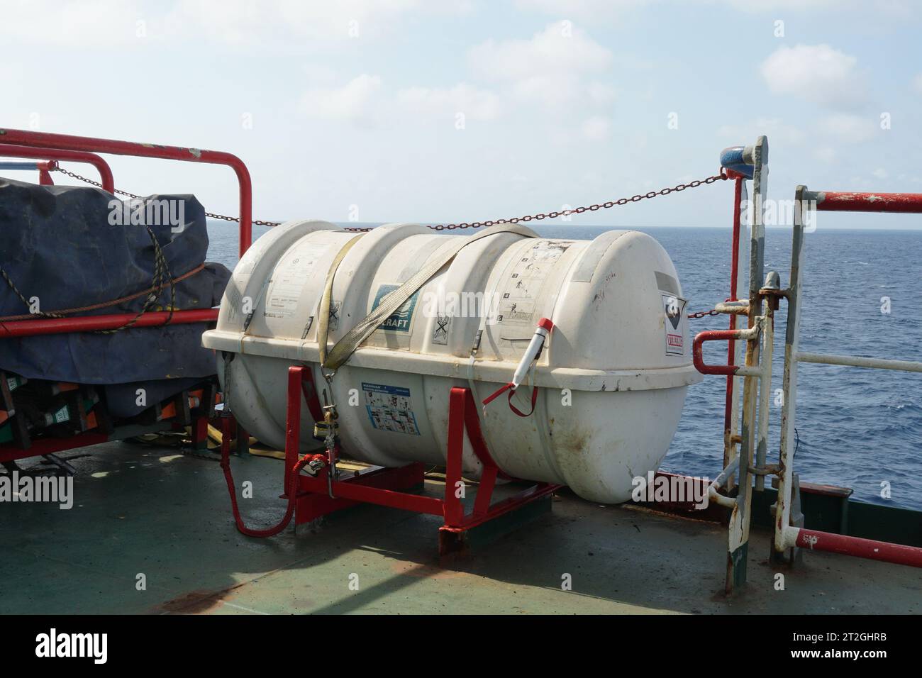 White life raft secured on deck of container ship ready for use in ...