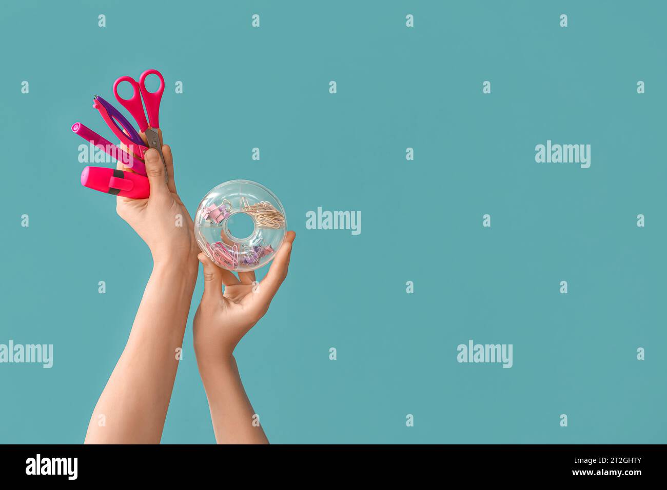Female hands holding school supplies on blue background Stock Photo - Alamy