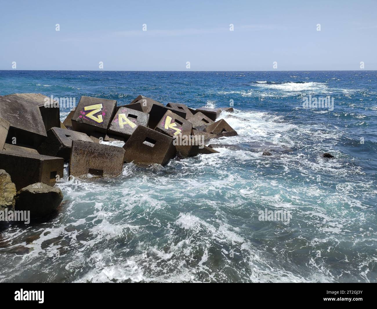 Angular photograph of the breakwater of cement cubes breaking the waves ...