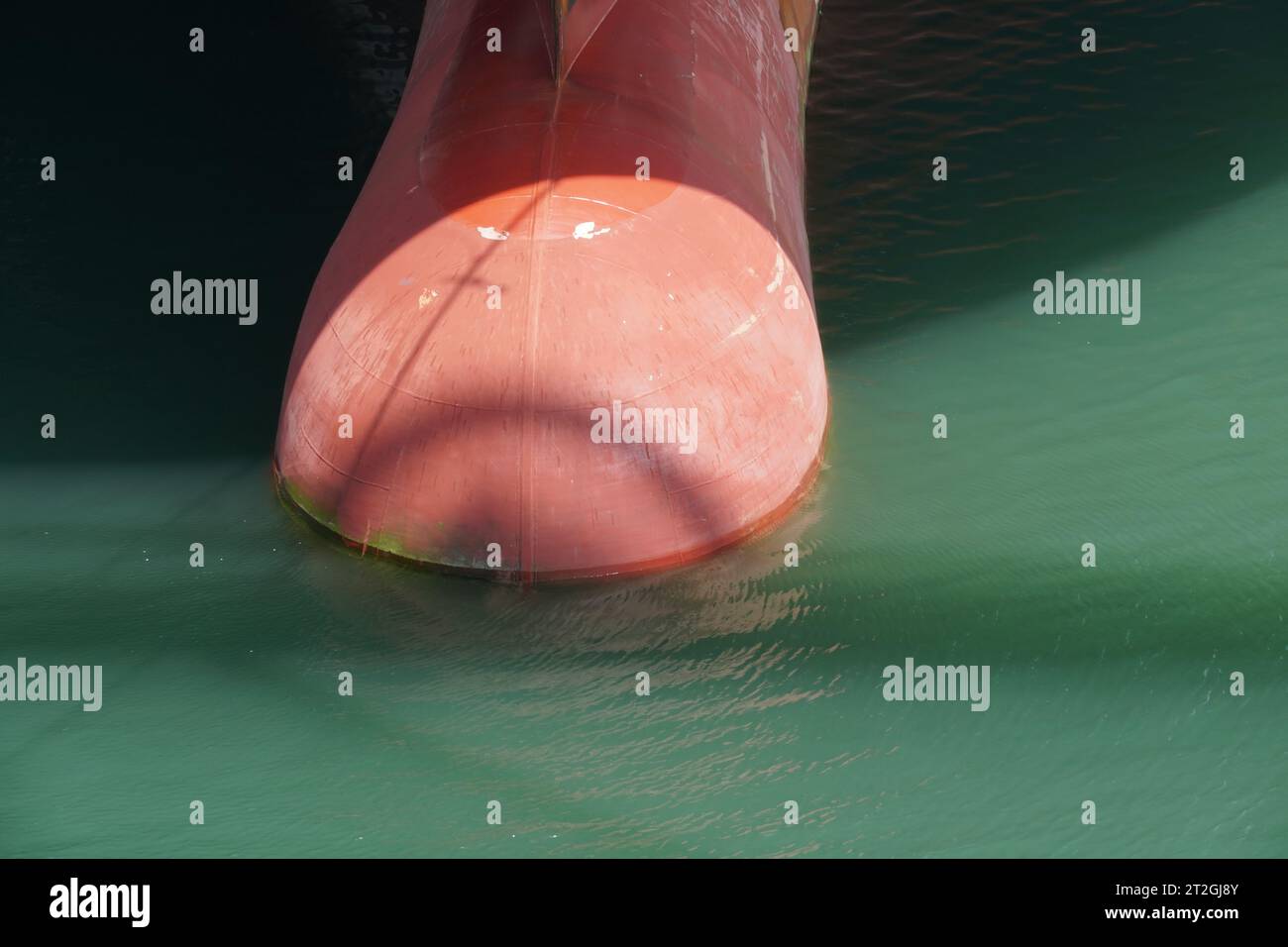 Red bulbous bow of container vessel in detail view, which is half ...
