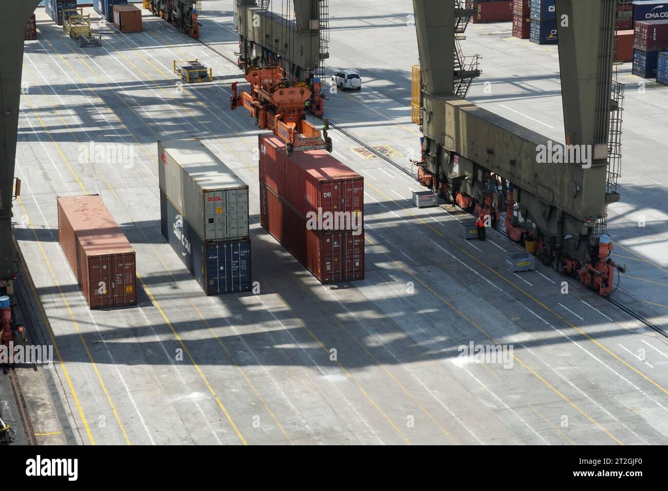 Orange spreader of gantry crane operated by stevedores approaching ...