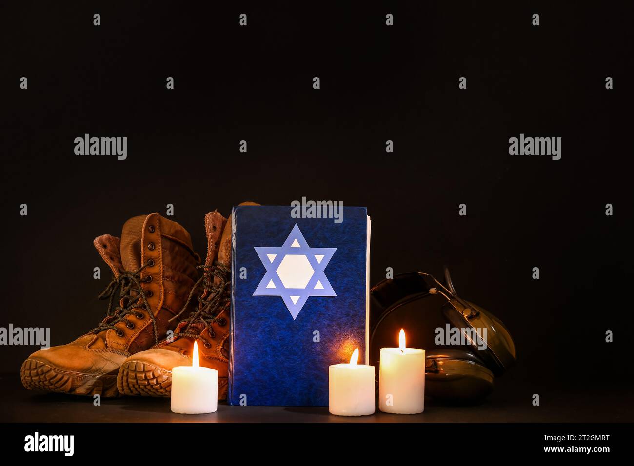 Torah with burning candles and military ammunition on dark background ...