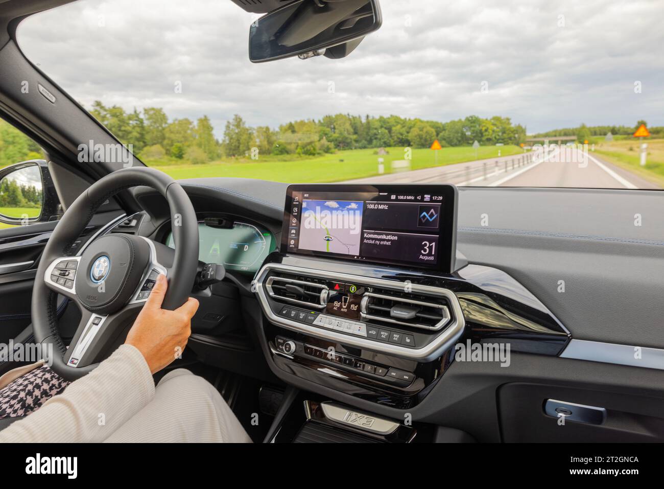View interior of BMW iX3 M-sport electric car driving along highway ...