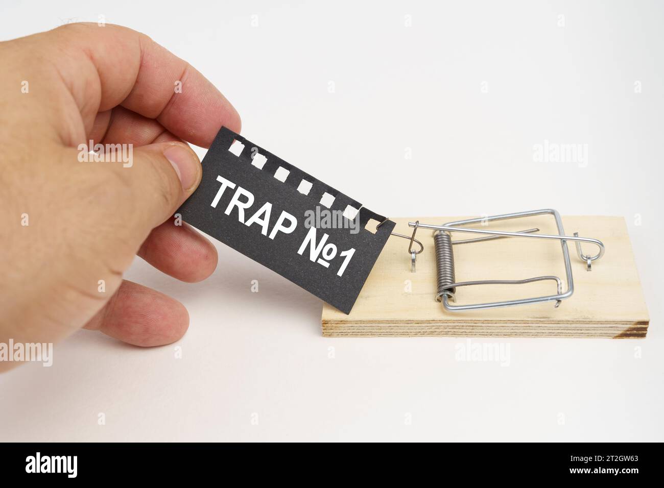 A man pulls the bait from a mousetrap. Bait, a sheet of black paper ...