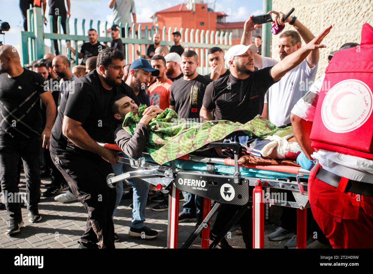 Paramedics and young men transport some injured Palestinians to the ...