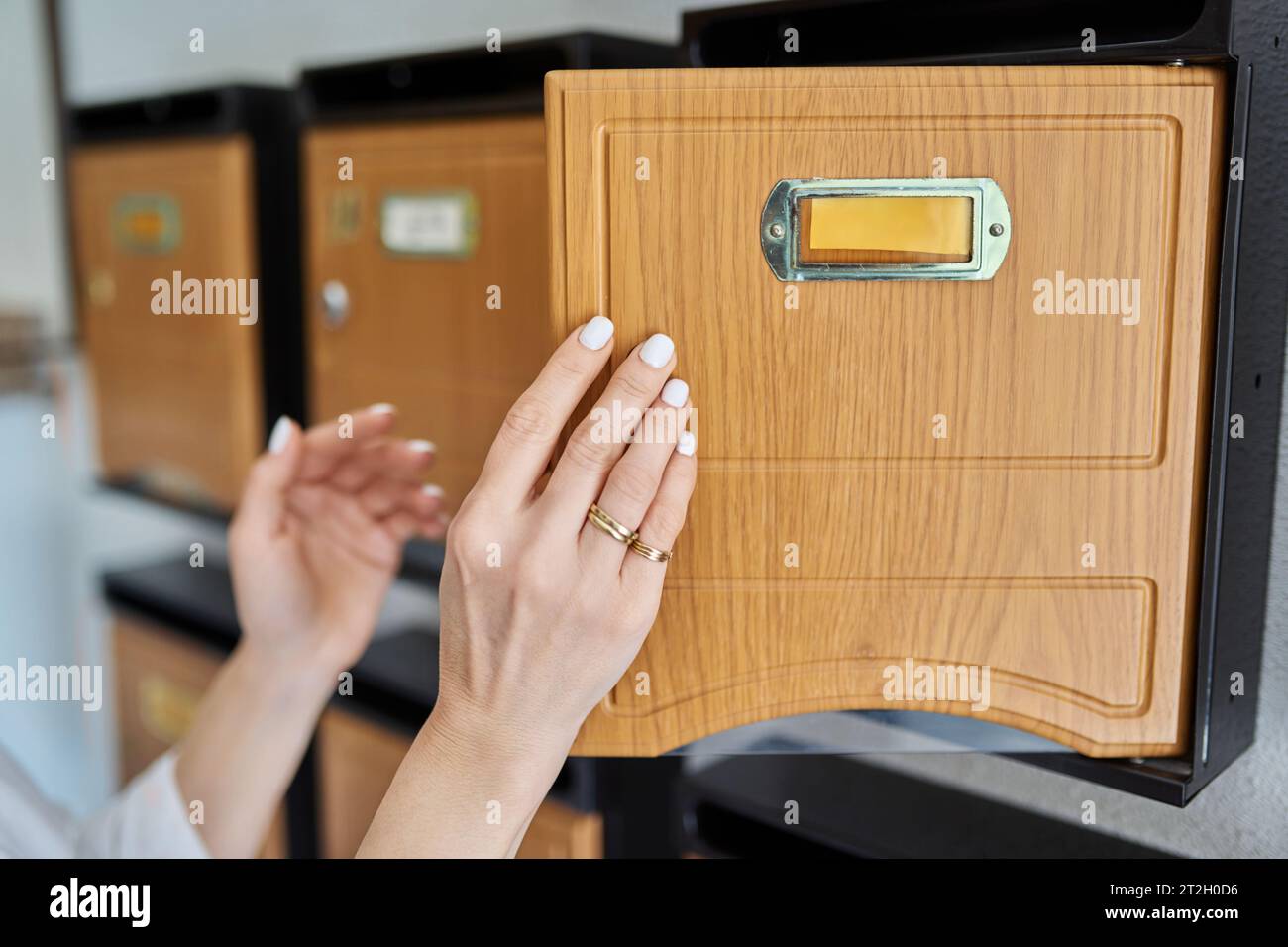 Woman checking mailboxes inside an apartment building Stock Photo - Alamy