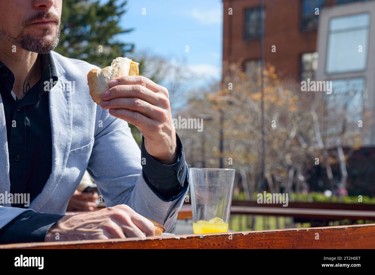 Close-up of unrecognizable adult business man sitting at bar outside ...