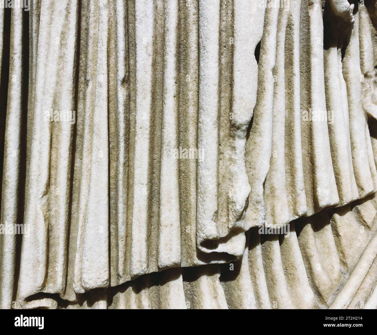 ancient texture. beige stone, voluminous background. a statue in robes ...