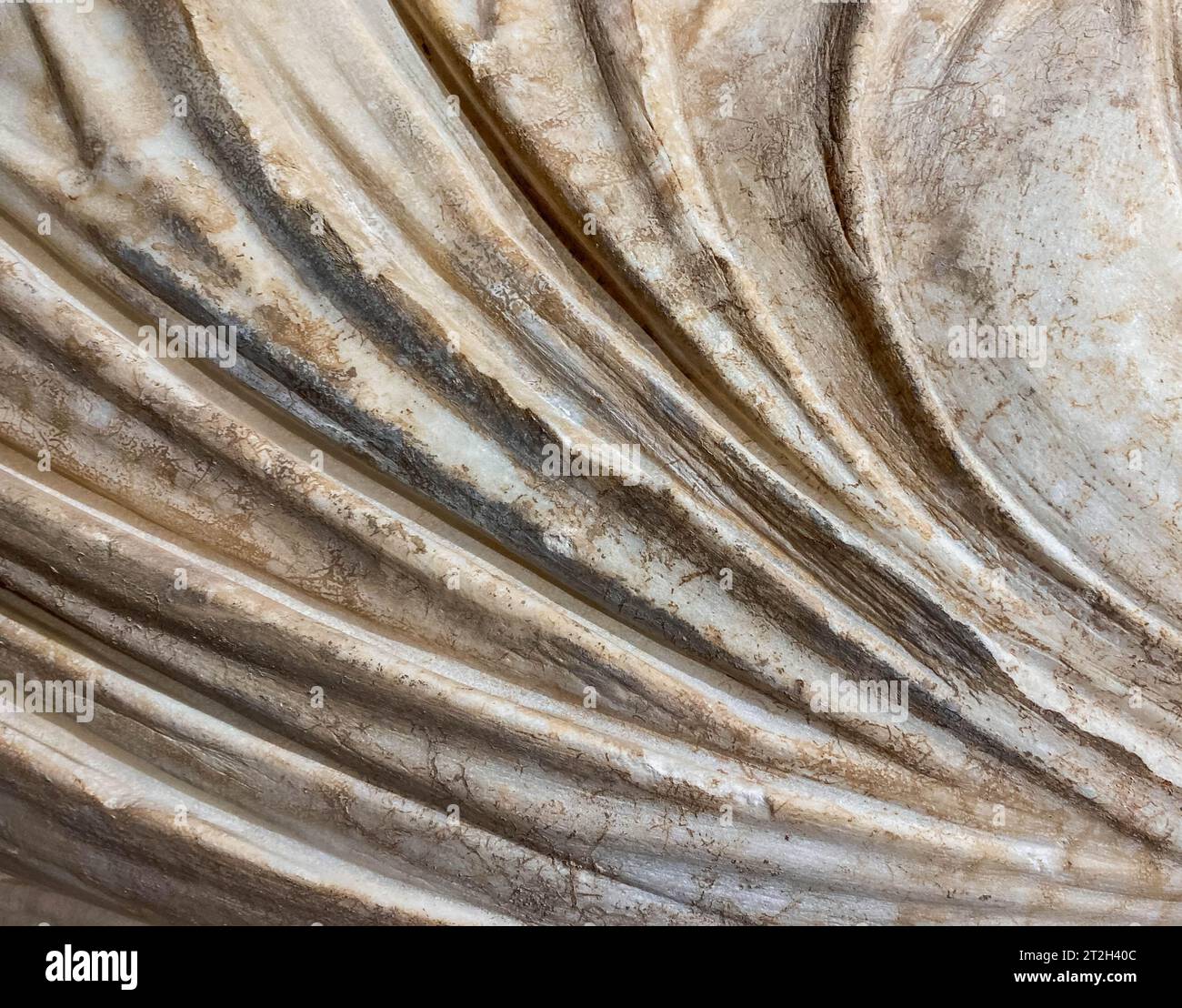 ancient texture. beige stone, voluminous background. a statue in robes ...