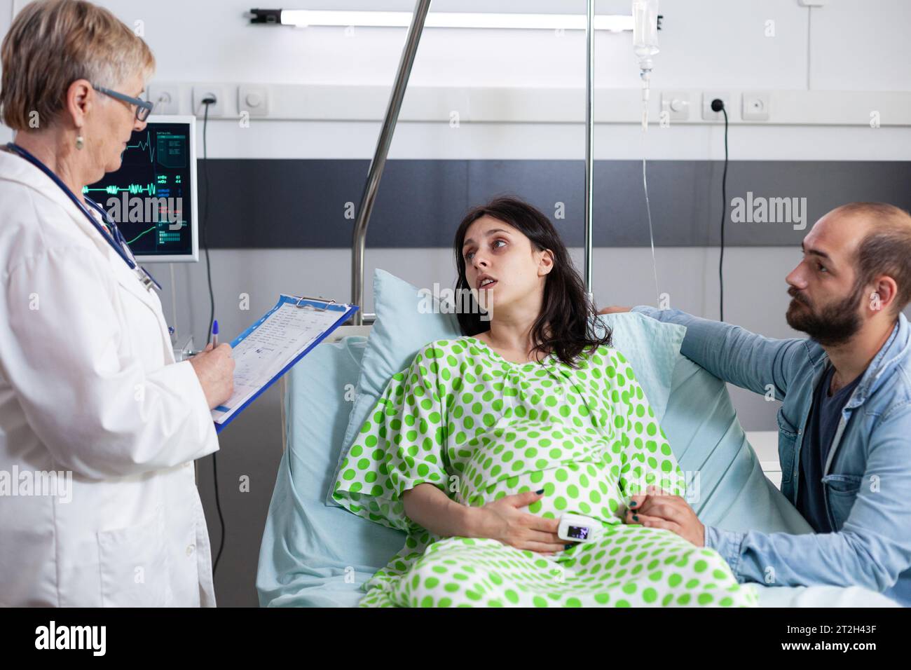 Doctor explaining labor symptoms to pregnant woman before medical ...