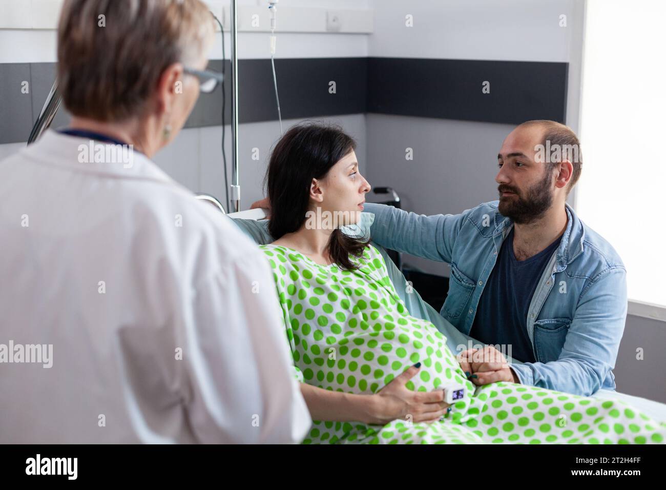 Future parents discussing labor process with medic in hospital ward ...