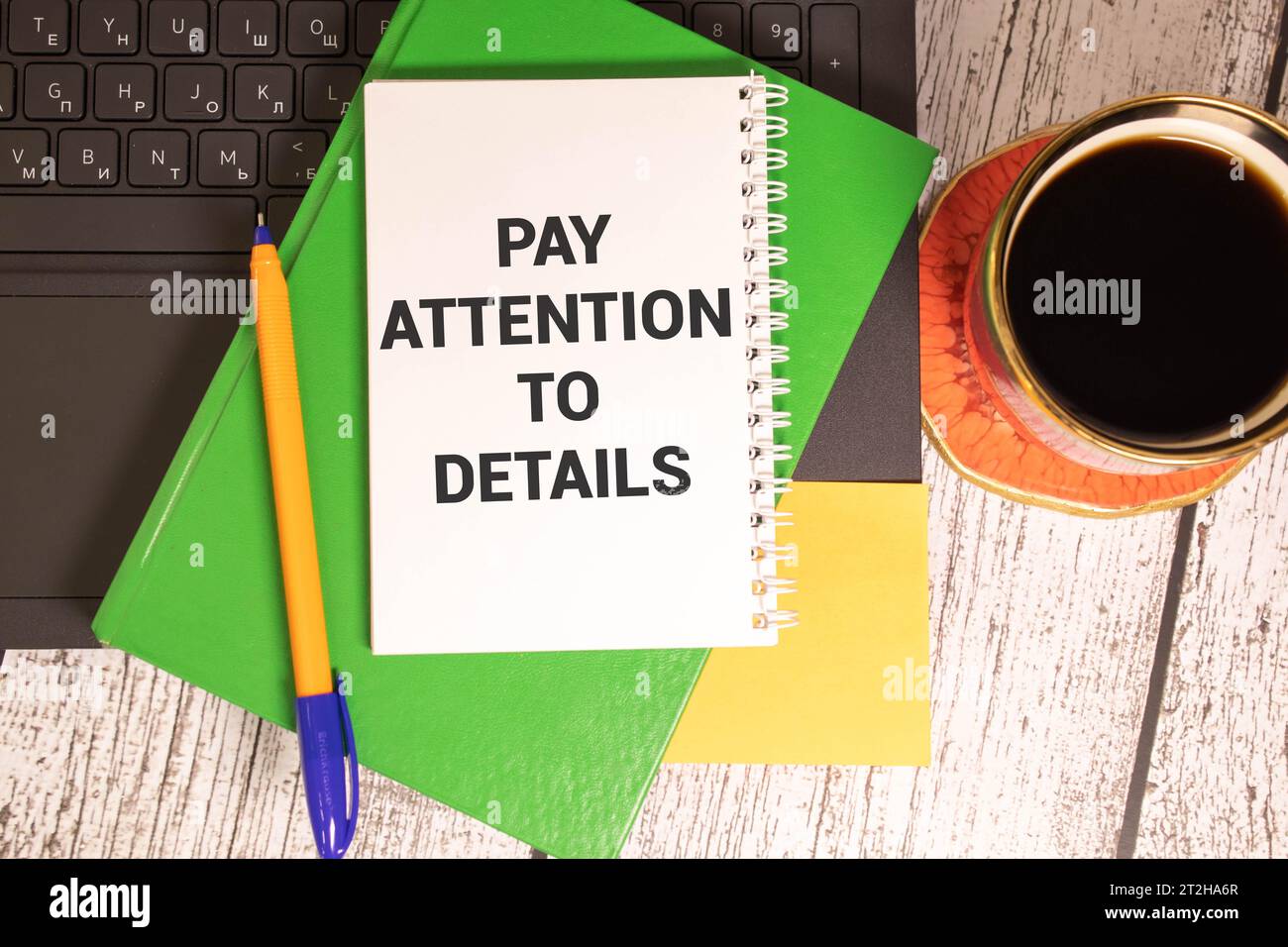 Word text attention to detail on white paper card on office table ...