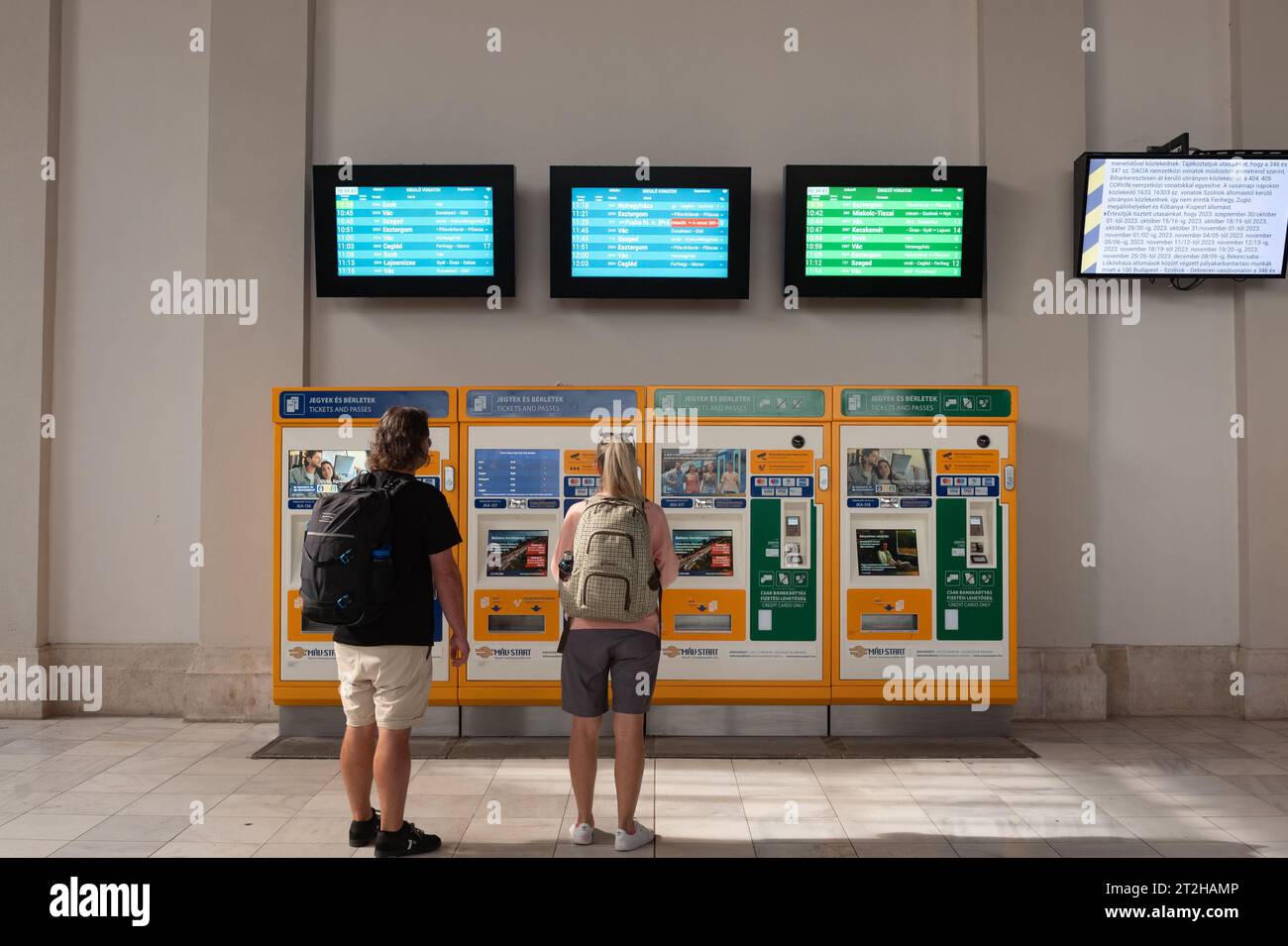 Tourists buying a train tickets from automatic machines at Nyugati ...