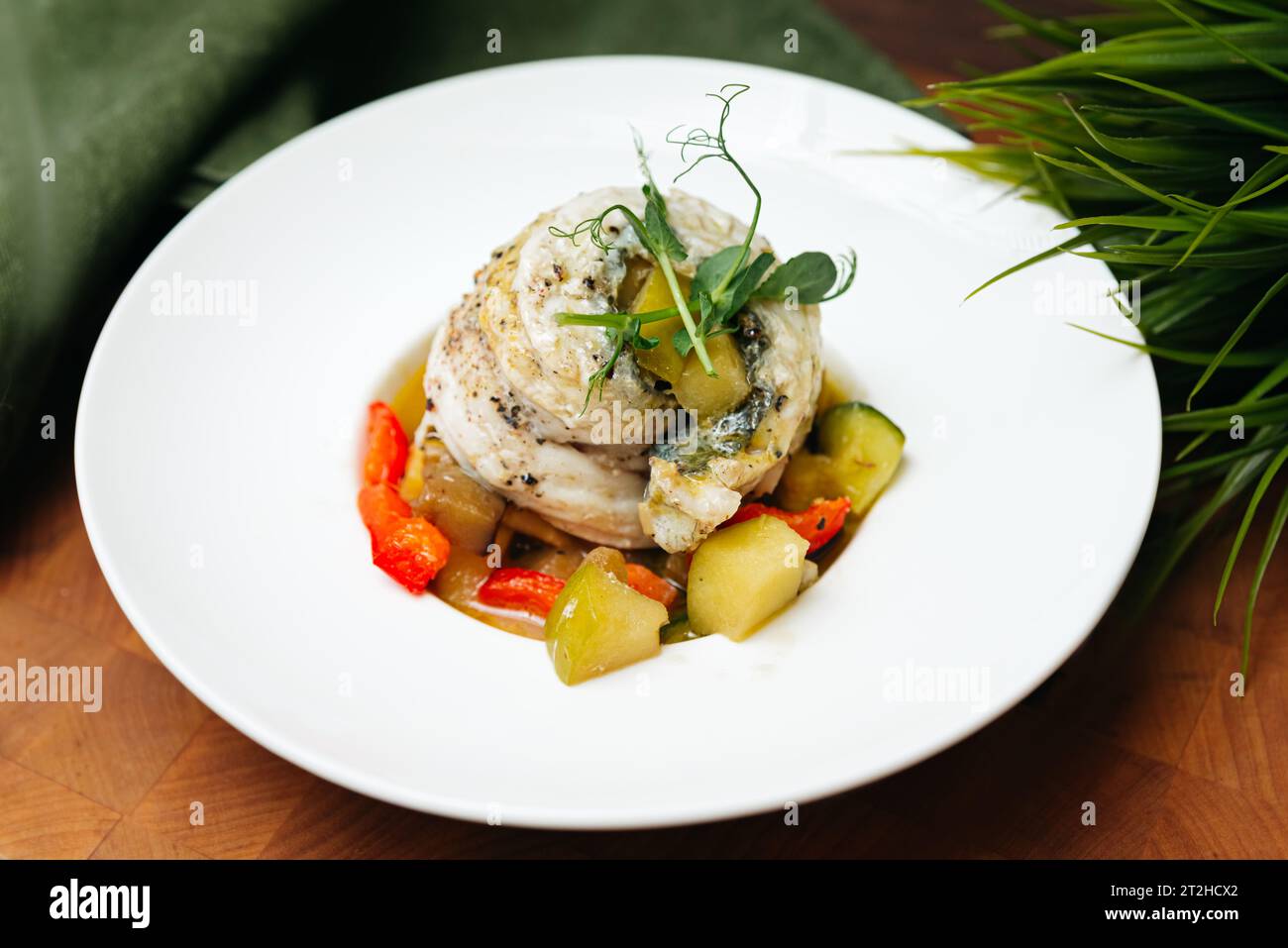 Baked sea bass fillet with chopped apples, red sweet pepper, and zucchini Stock Photo - Alamy