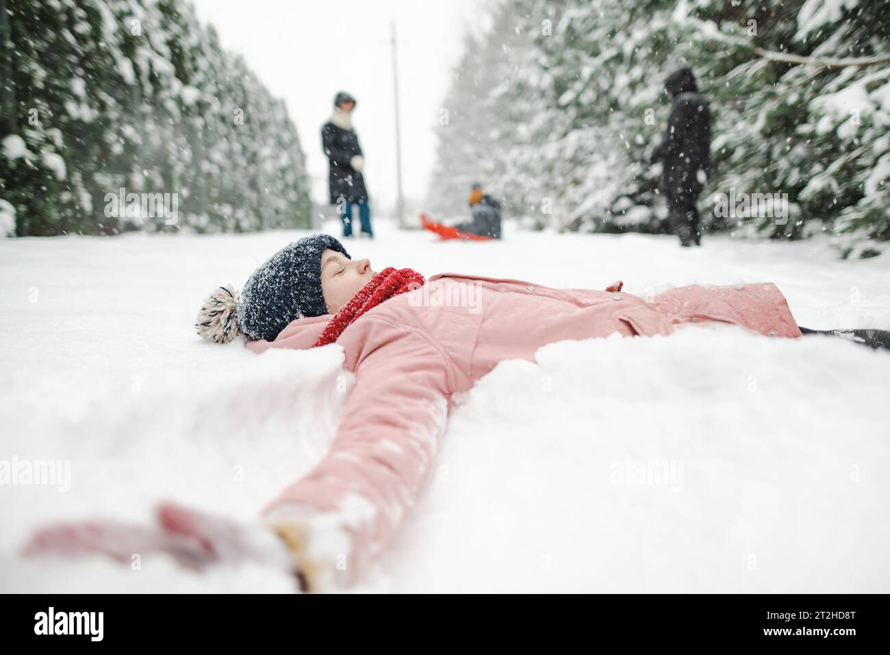 Cute teen girl having fun on a walk in snow covered pine forest on ...