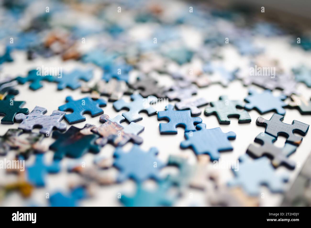Playing puzzles at home. Connecting jigsaw puzzle pieces in a living room table. Fun family ...