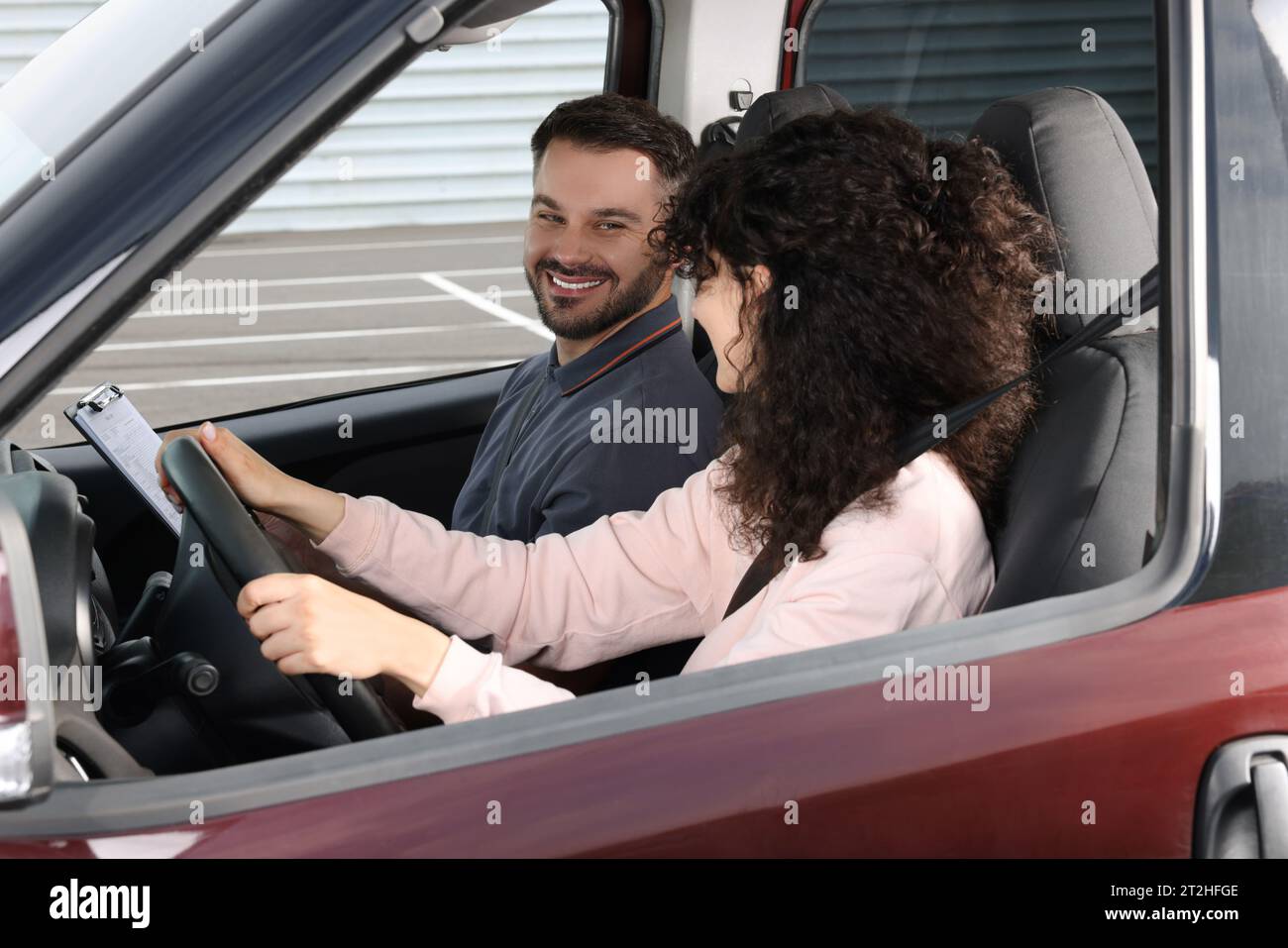 Driving school. Happy student passing driving test with examiner in car ...