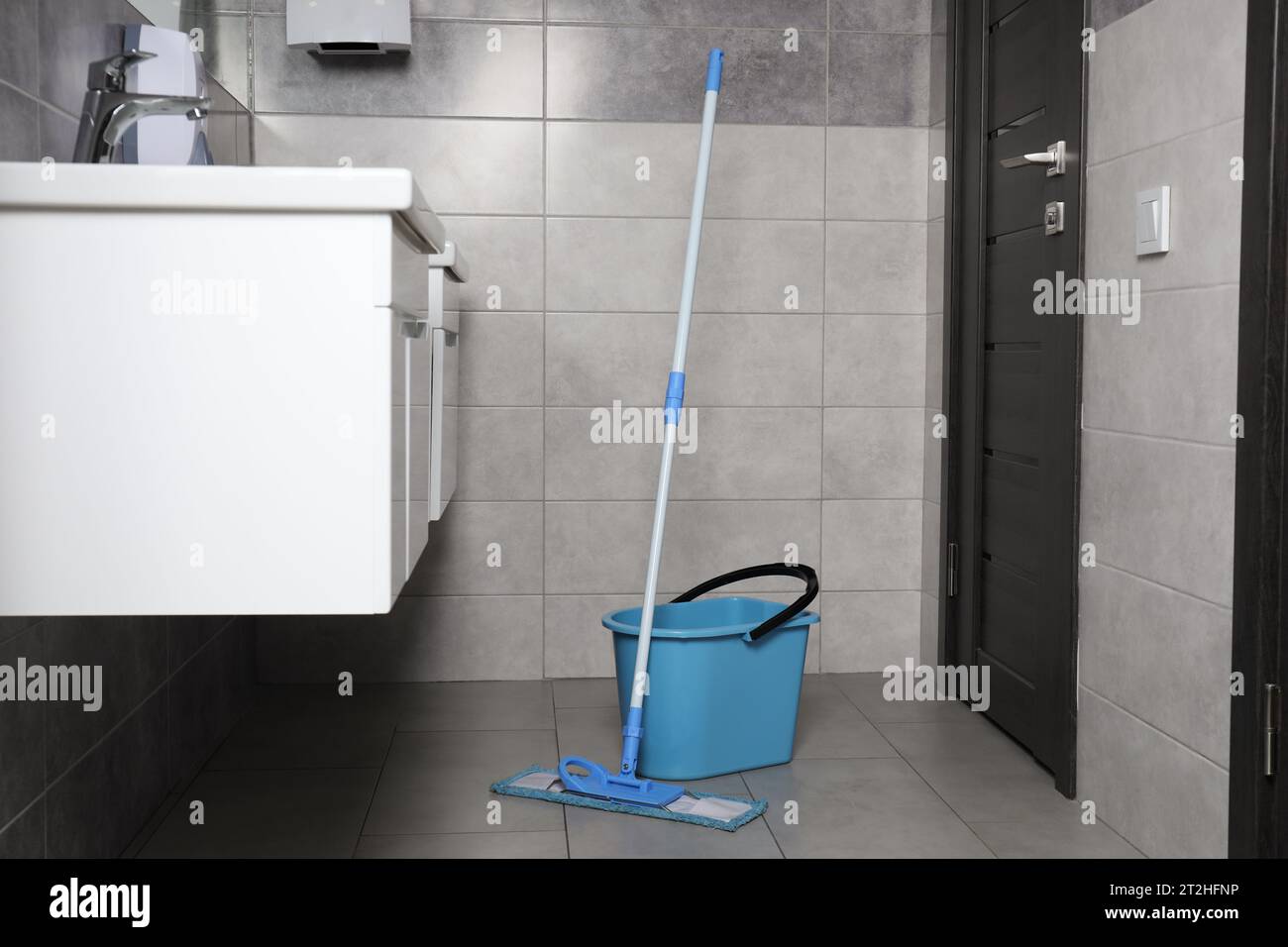 Mop and bucket near sinks in public toilet Stock Photo - Alamy