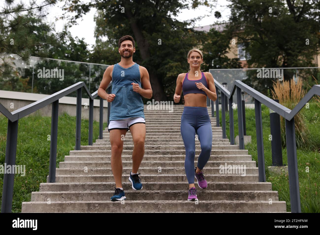 Healthy lifestyle. Happy couple running down stairs outdoors Stock ...