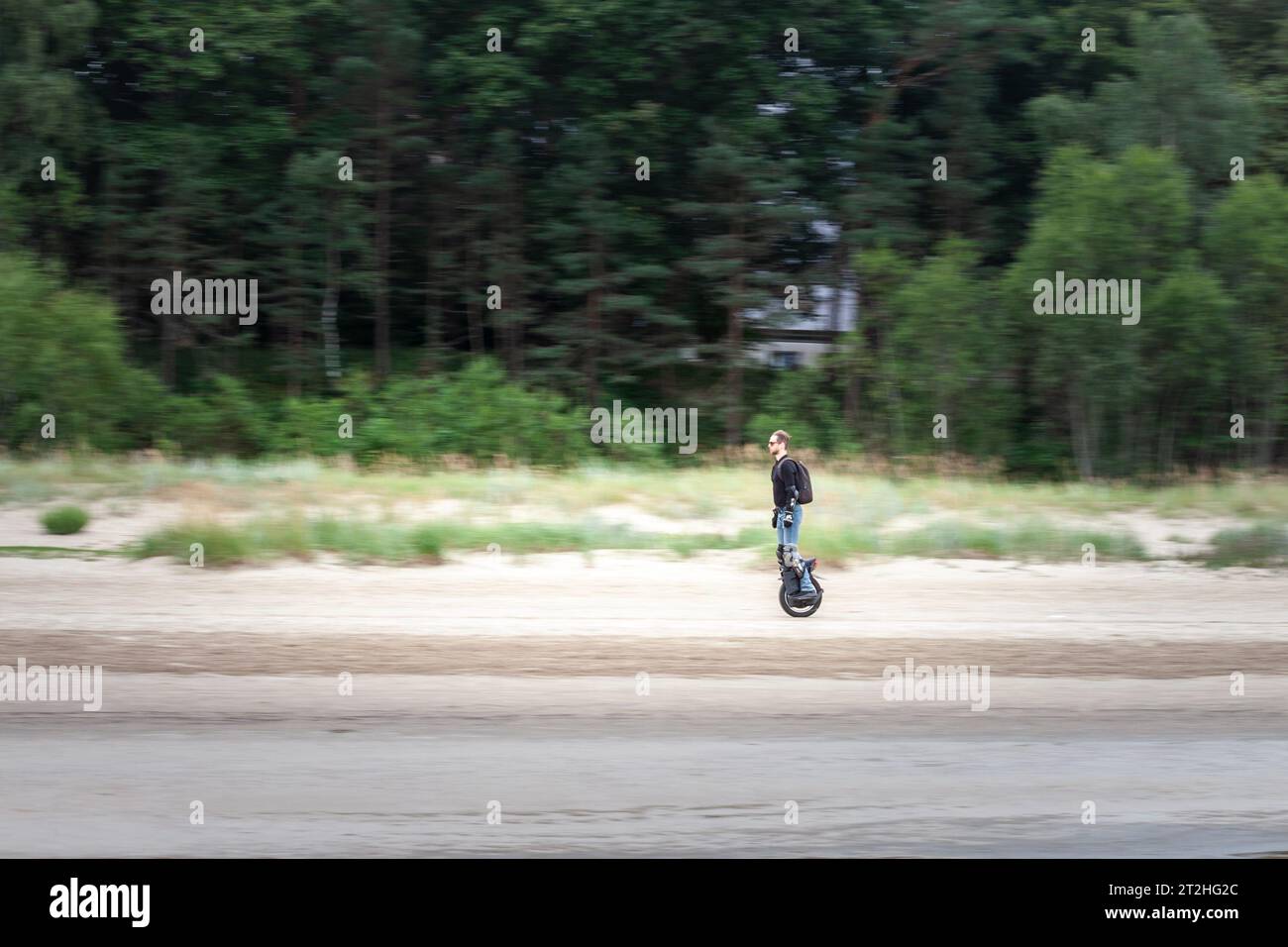 Picture of a man driving a segway on the sand in Jurmala, on a beach ...