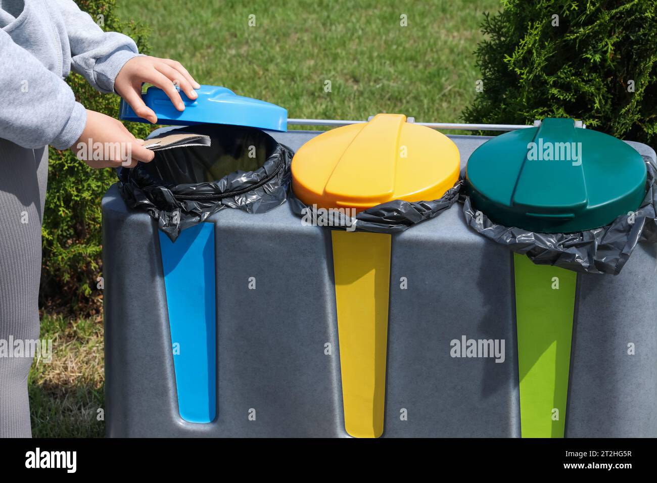 Woman throwing cardboard in bin outdoors, closeup. Recycling concept ...