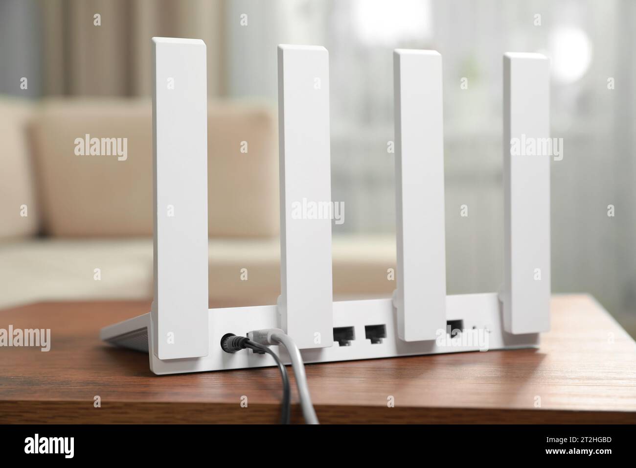 New modern Wi-Fi router on wooden table indoors Stock Photo - Alamy