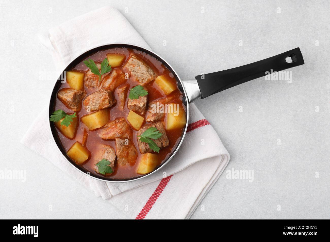 Delicious goulash in saucepan on light grey table, top view Stock Photo ...