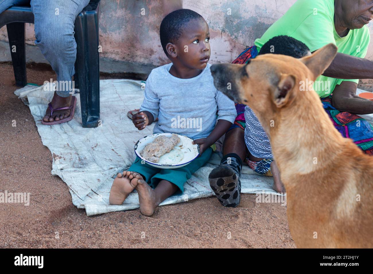 poverty in the village, african child eating in the yard some porridge ...