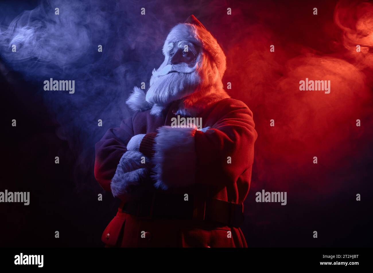 Santa Claus stands with his arms crossed on his chest in blue red neon ...