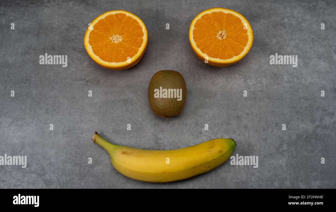 Happy smiling fruit face on stone background Stock Photo - Alamy
