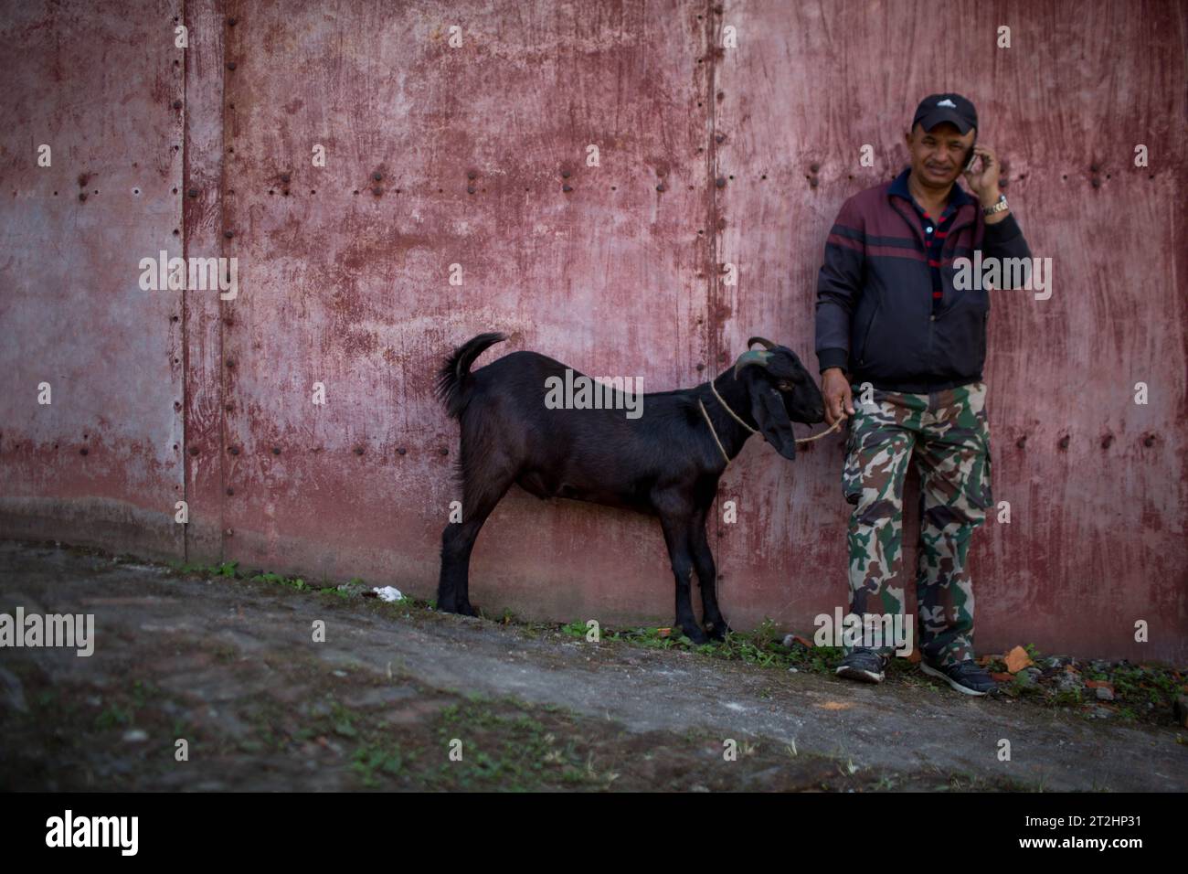 Kathmandu, Nepal. 19th Oct, 2023. A man and a goat are pictured at a ...