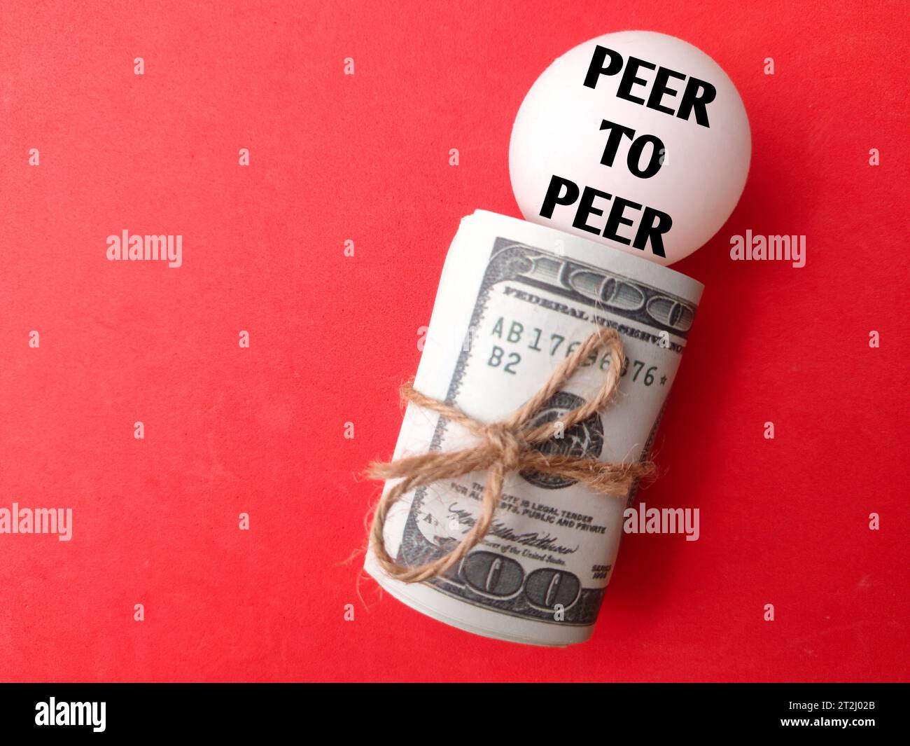 Banknotes and ping pong ball with word PEER TO PEER on red background ...