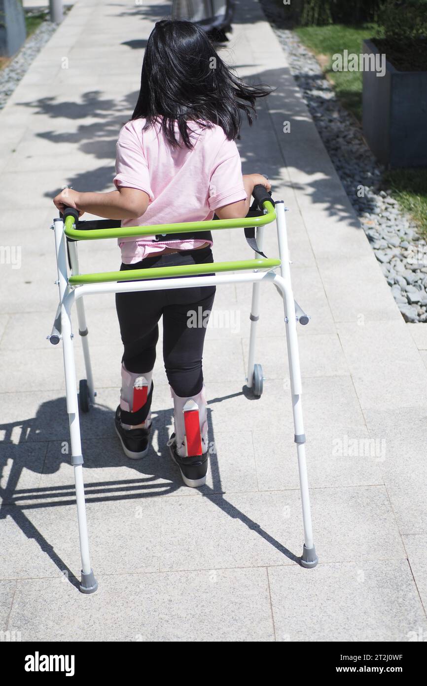 child with walking frame and knee orthosis outdoor Stock Photo - Alamy