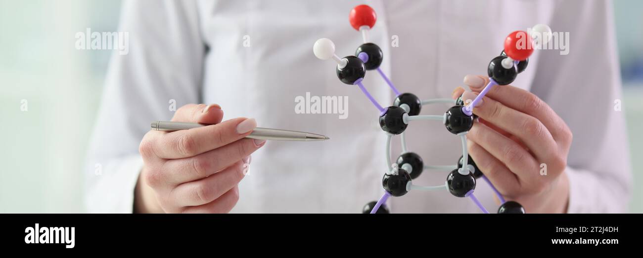 Woman chemist points pen to molecule model holding in hand Stock Photo ... Woman chemist points pen to molecule model holding in hand Stock Photo ...