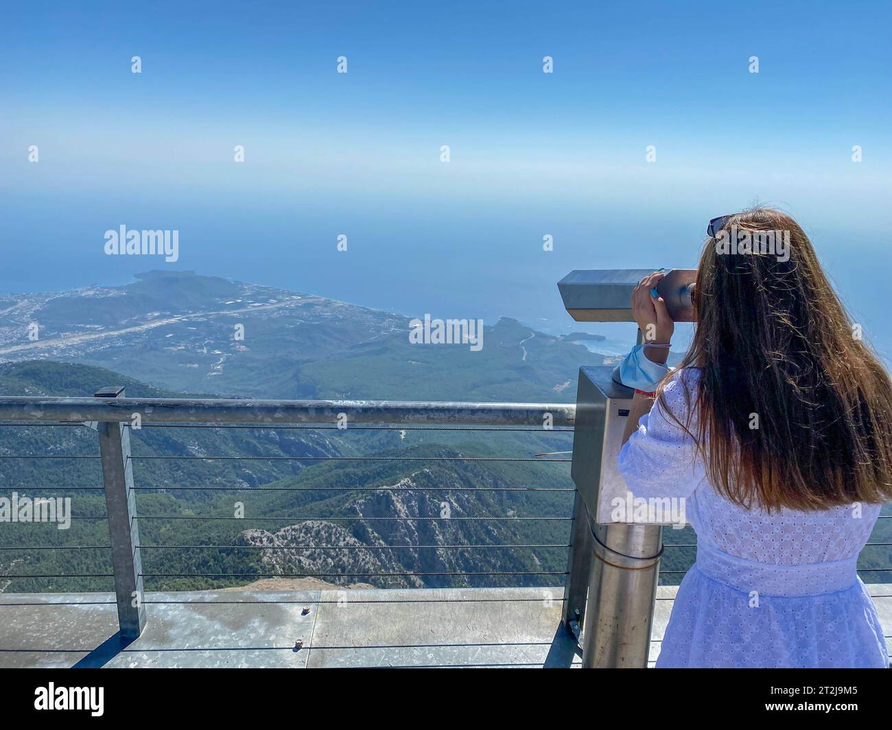 Young woman tourist in summer dress using monocular telescope ...