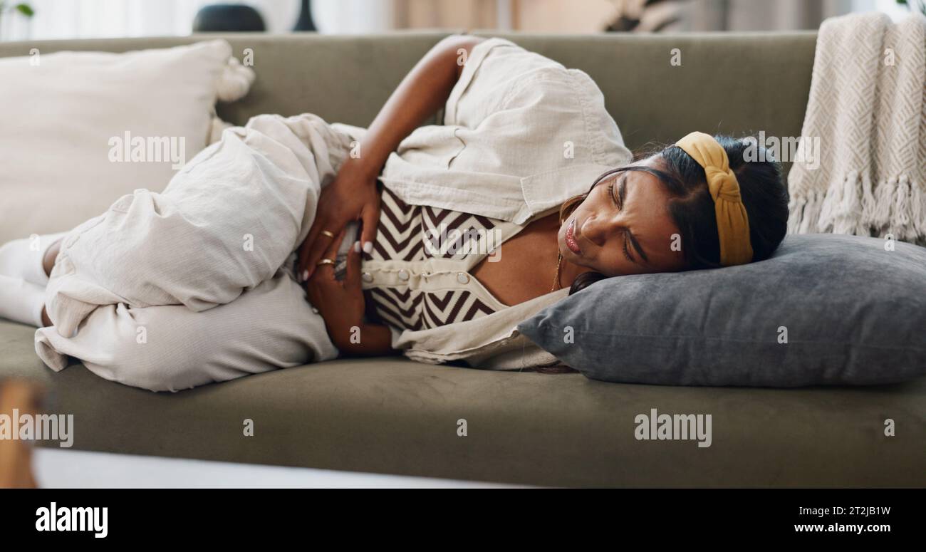 Stress, anxiety and woman with stomach pain on sofa for gas ...