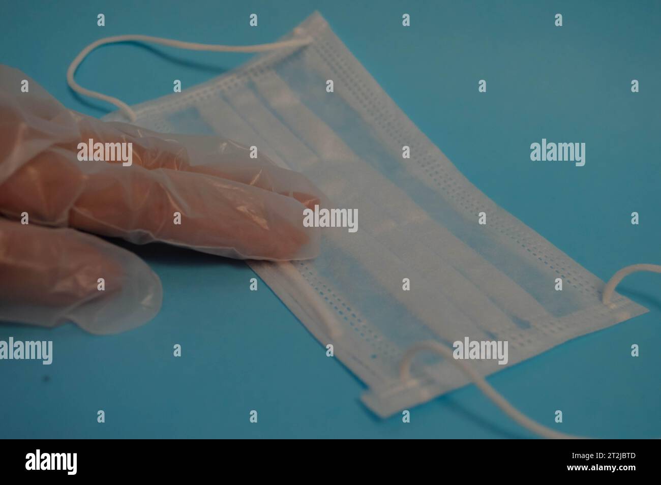 the female hand with manicure is hidden in transparent gloves. the hand ...