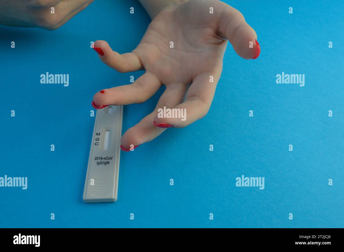 blood test for the diagnosis of coronavirus. a girl with a bright red ...
