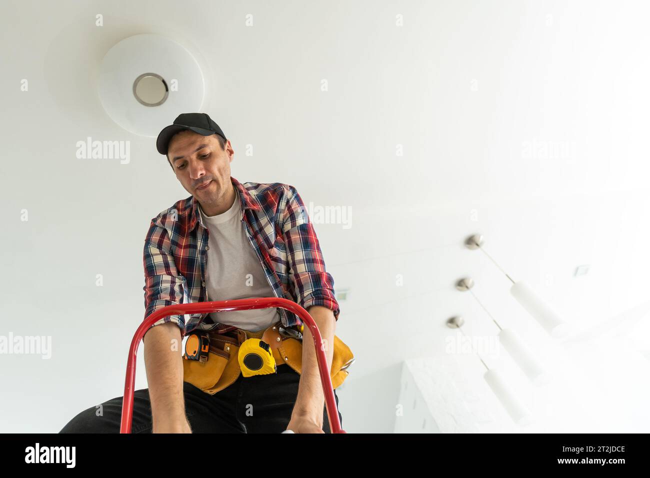 Electrician man worker installing ceiling lamp Stock Photo - Alamy