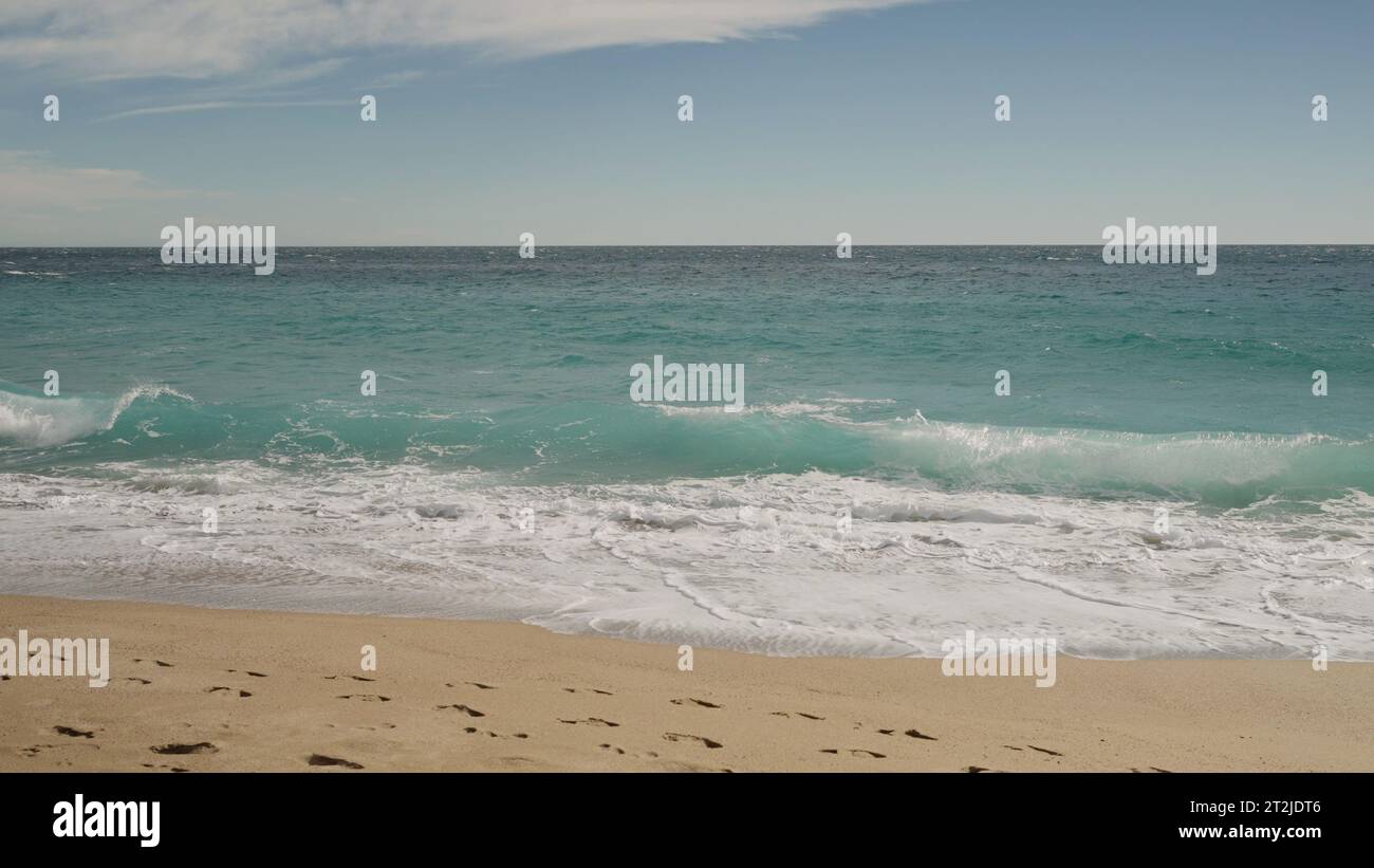Clear blue waves with strong wind on a sandy empty beach in Cannes in ...