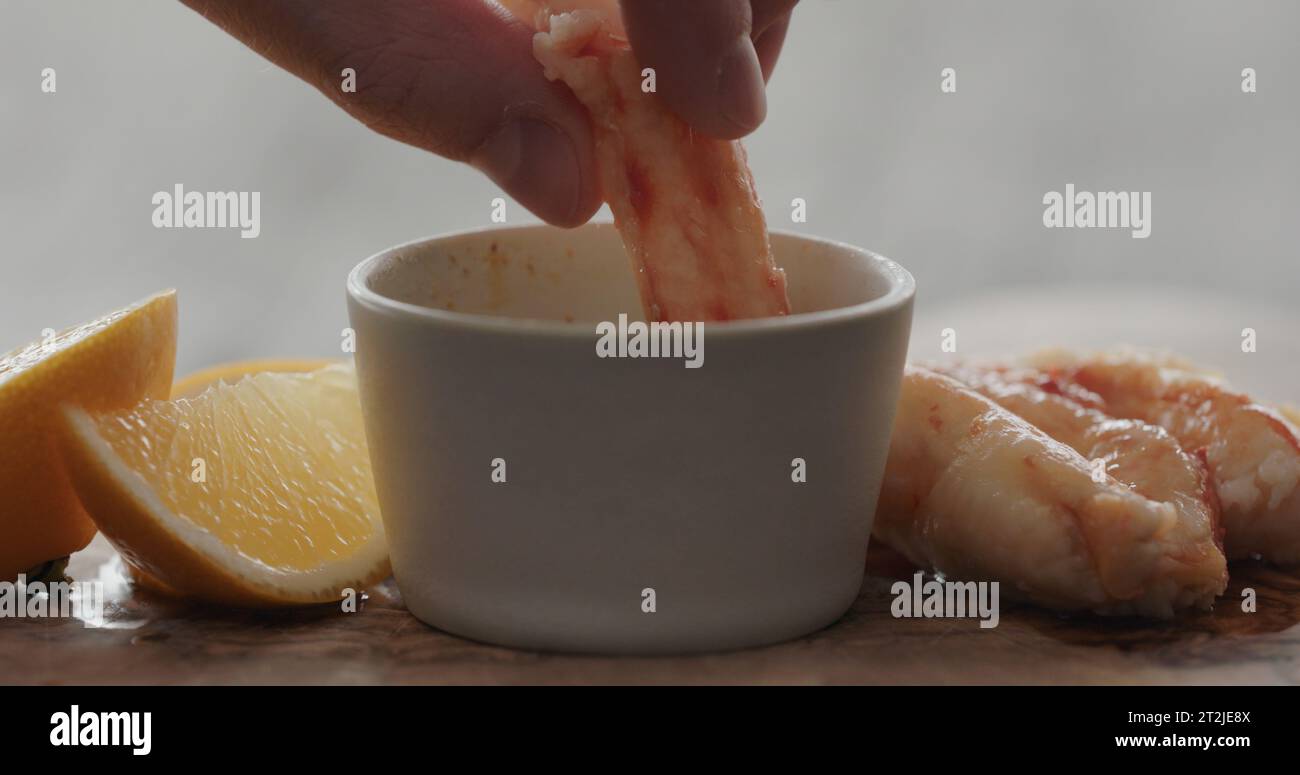 man eating crab with dip sauce, wide photo Stock Photo - Alamy