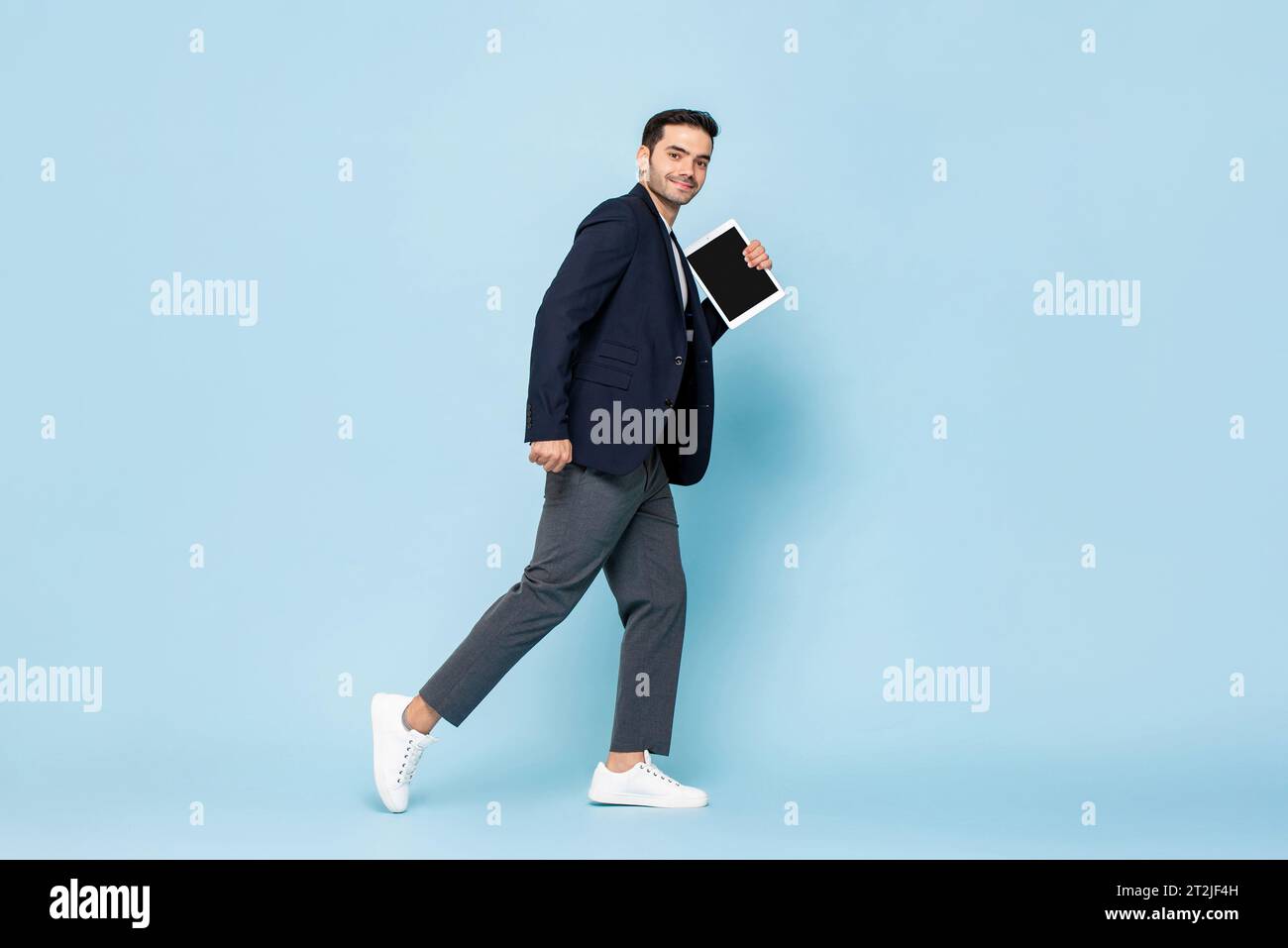 Positive Caucasian businessman carrying tablet with black screen and ...