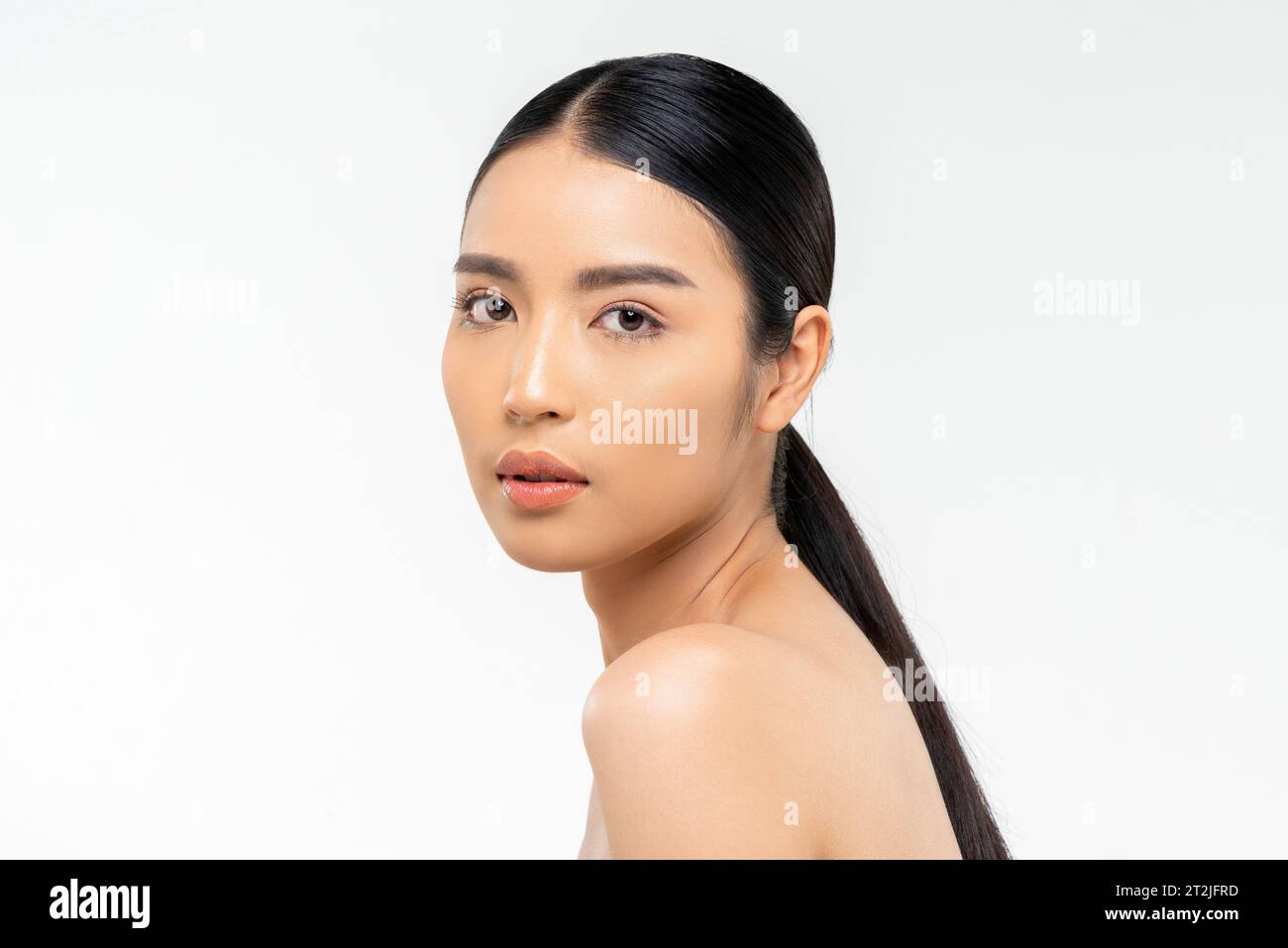 Beauty shot of pretty young Asian woman with clean face skin looking at ...