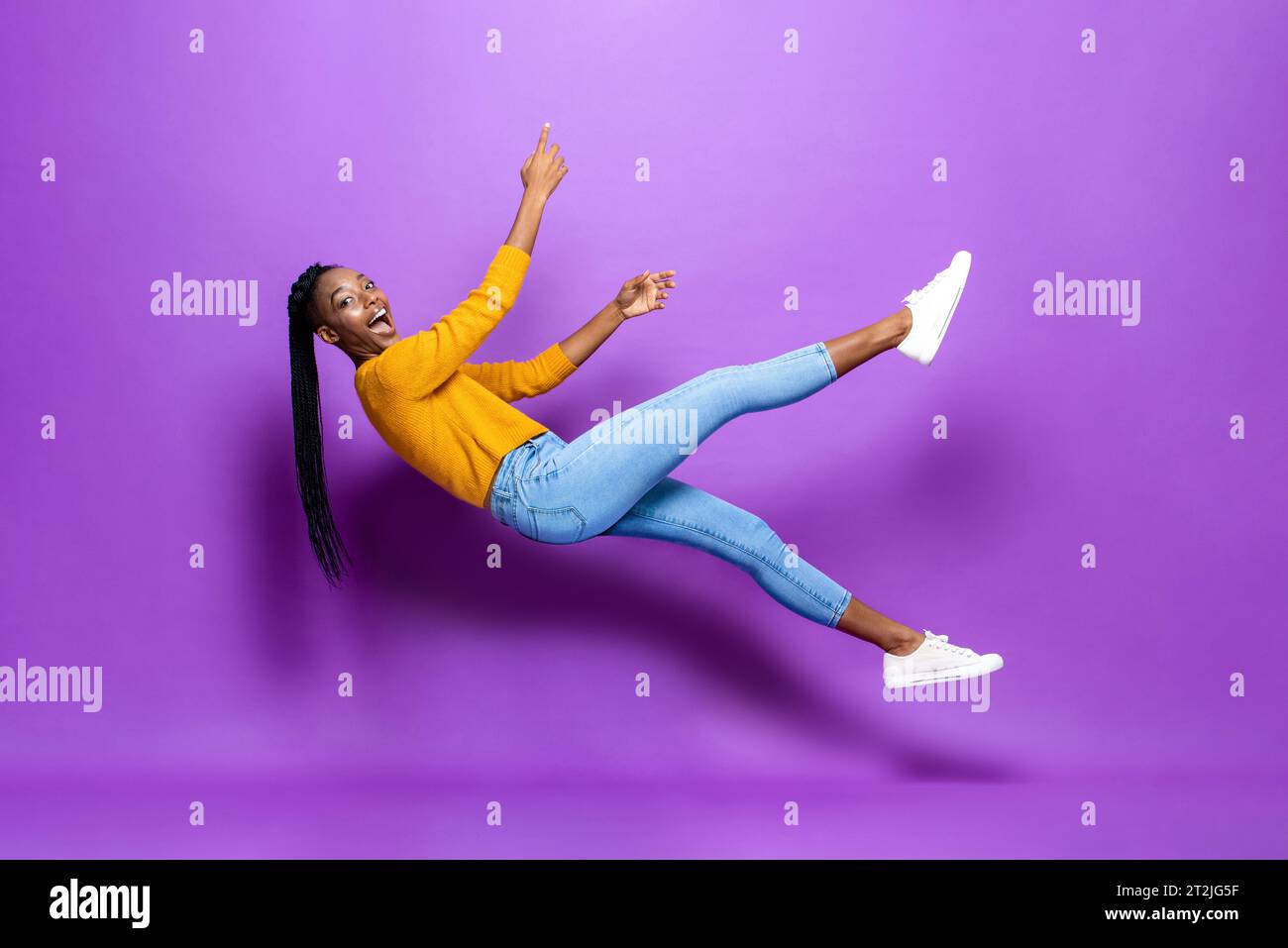 Full body side view of African American female in casual wear falling ...