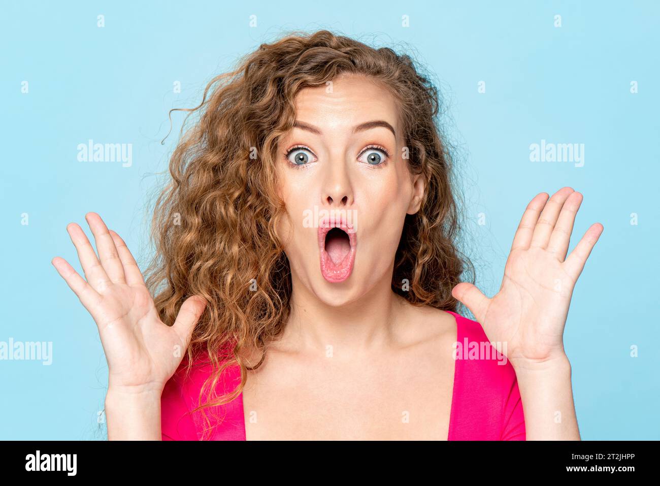 Shocked Caucasian woman screaming with open hands in isolated light ...