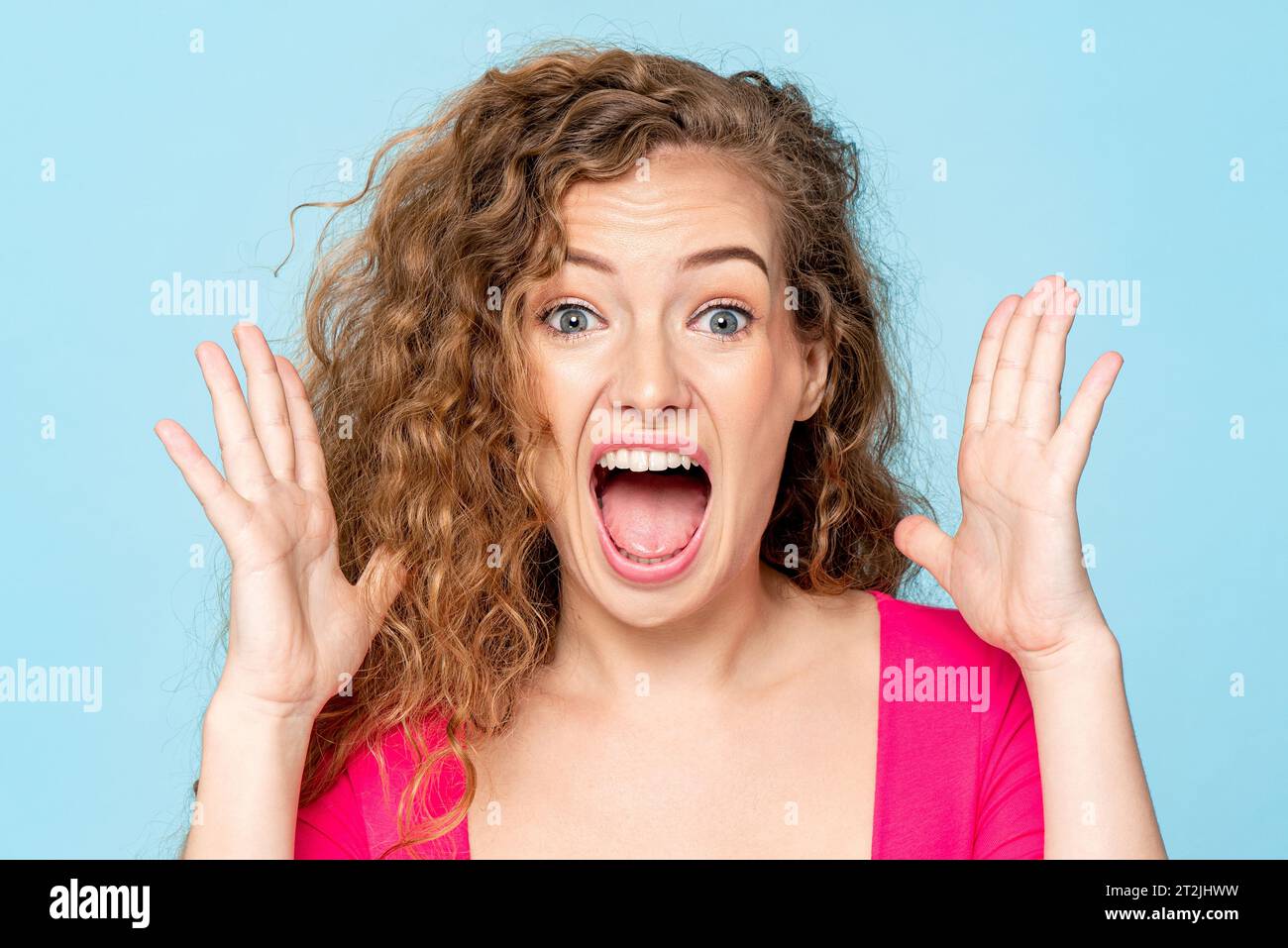 Ecstatic Caucasian woman screaming with open hands in isolated light ...