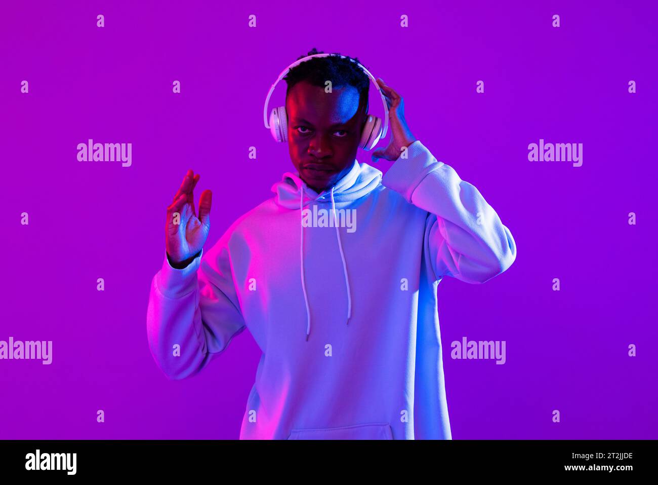 Young African man wearing wireless headphones listening to music in ...