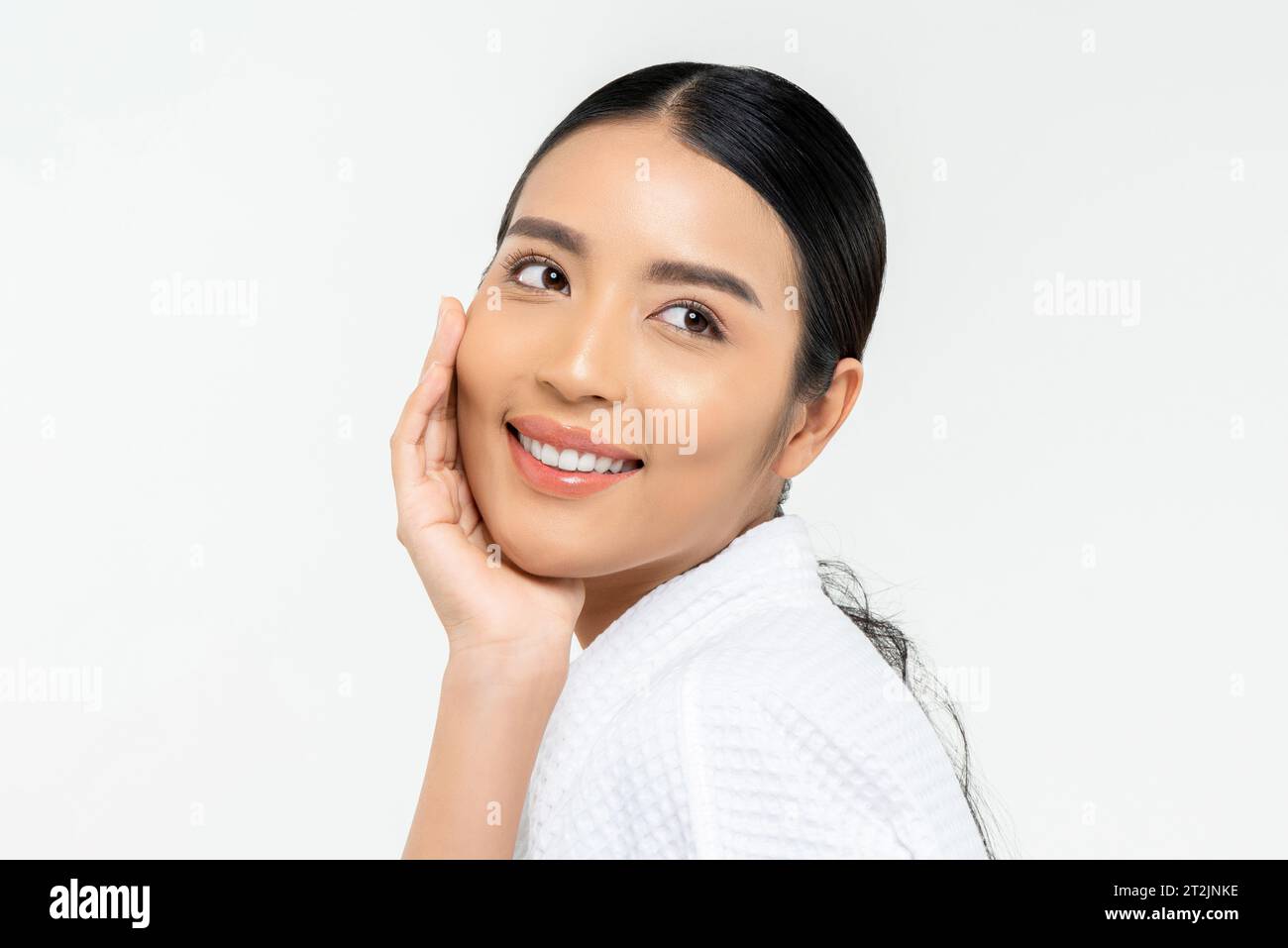 Beauty shot of positive Asian woman in bathrobe with smile while ...
